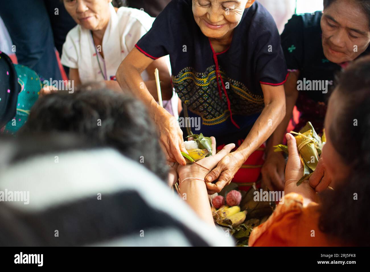 Karen traditional wrist tying ceremony: Tying white and red cotton ...
