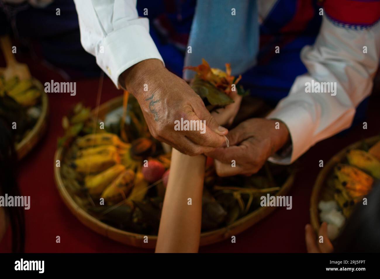Karen traditional wrist tying ceremony: Tying white and red cotton ...