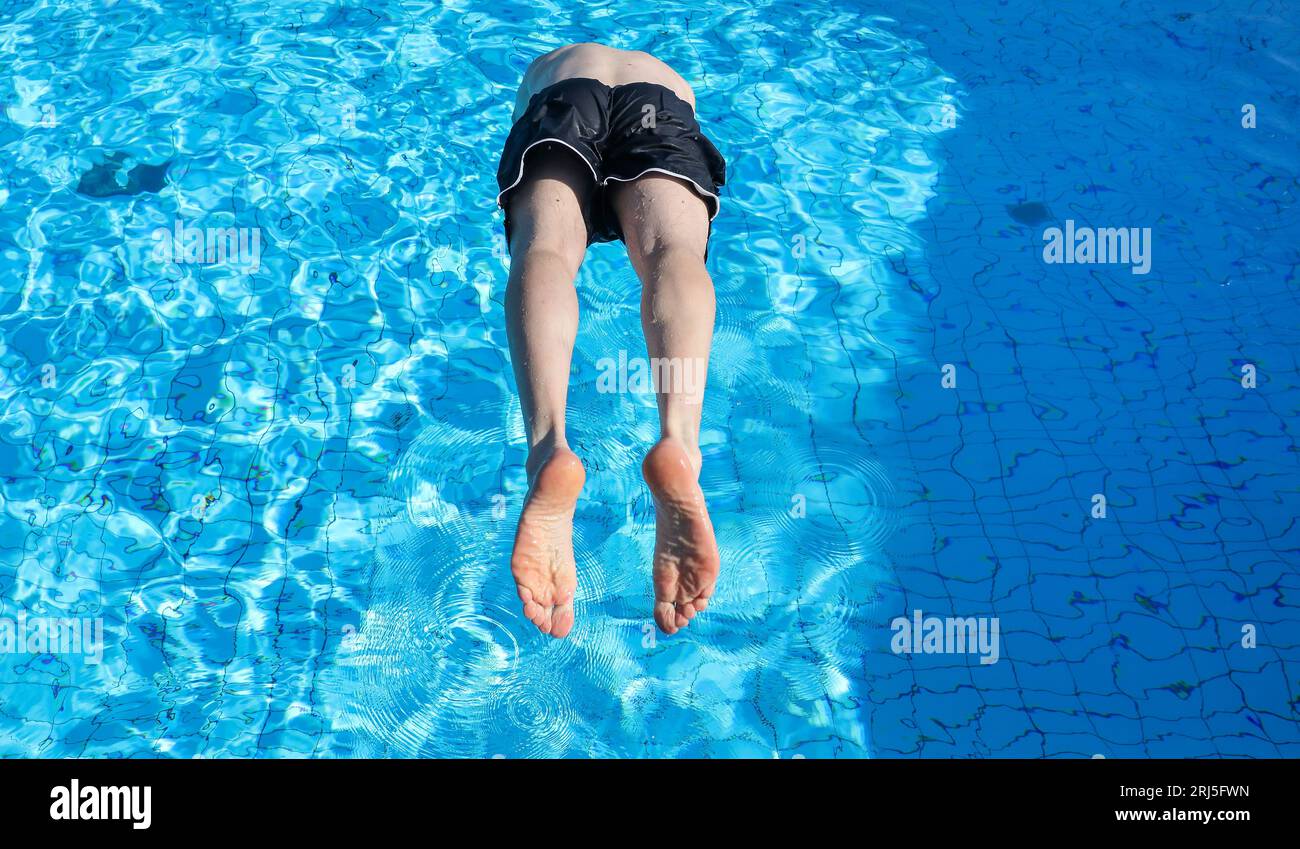 Mengen, Germany. 21st Aug, 2023. A man jumps into the water from a ...