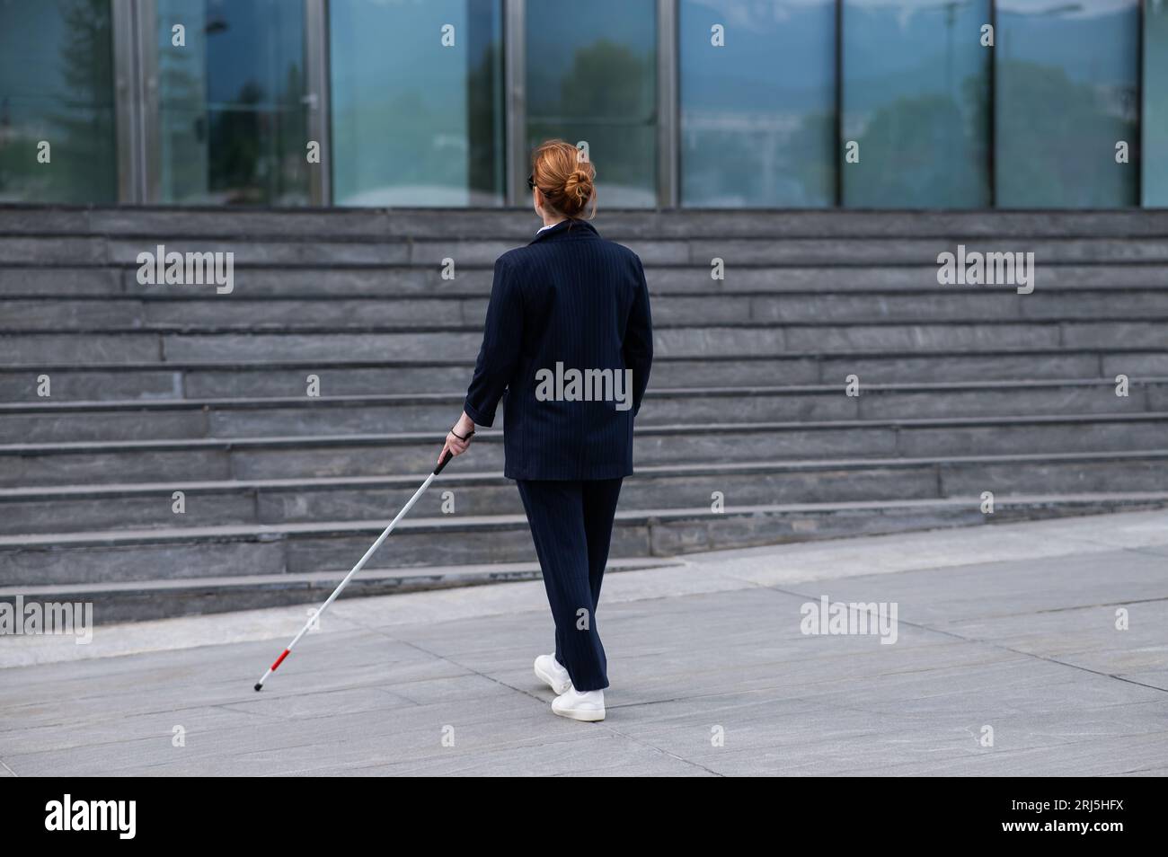 Blind businesswoman walking with tactile cane to business center Stock ...