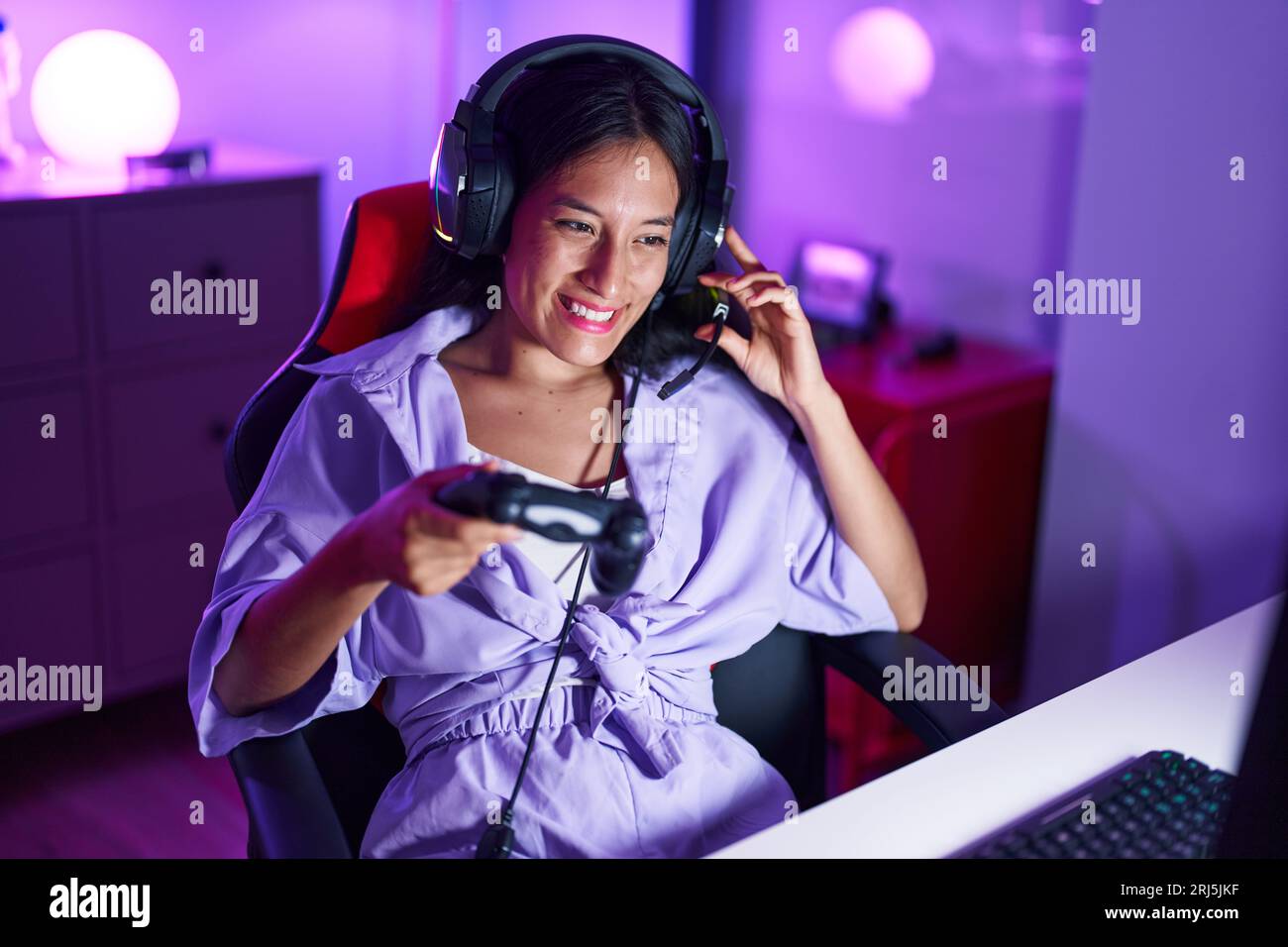 Young beautiful hispanic woman streamer playing video game using ...