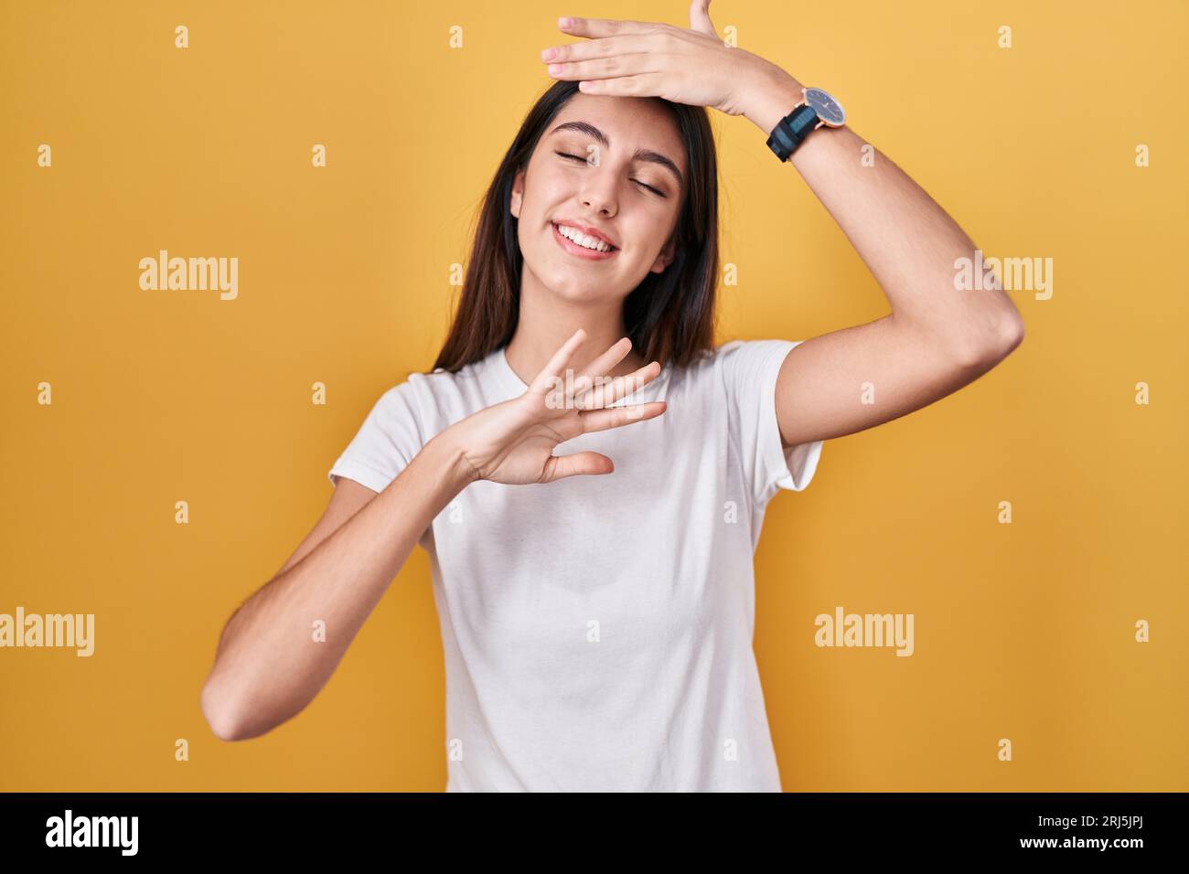 Young beautiful woman standing over yellow background smiling cheerful ...