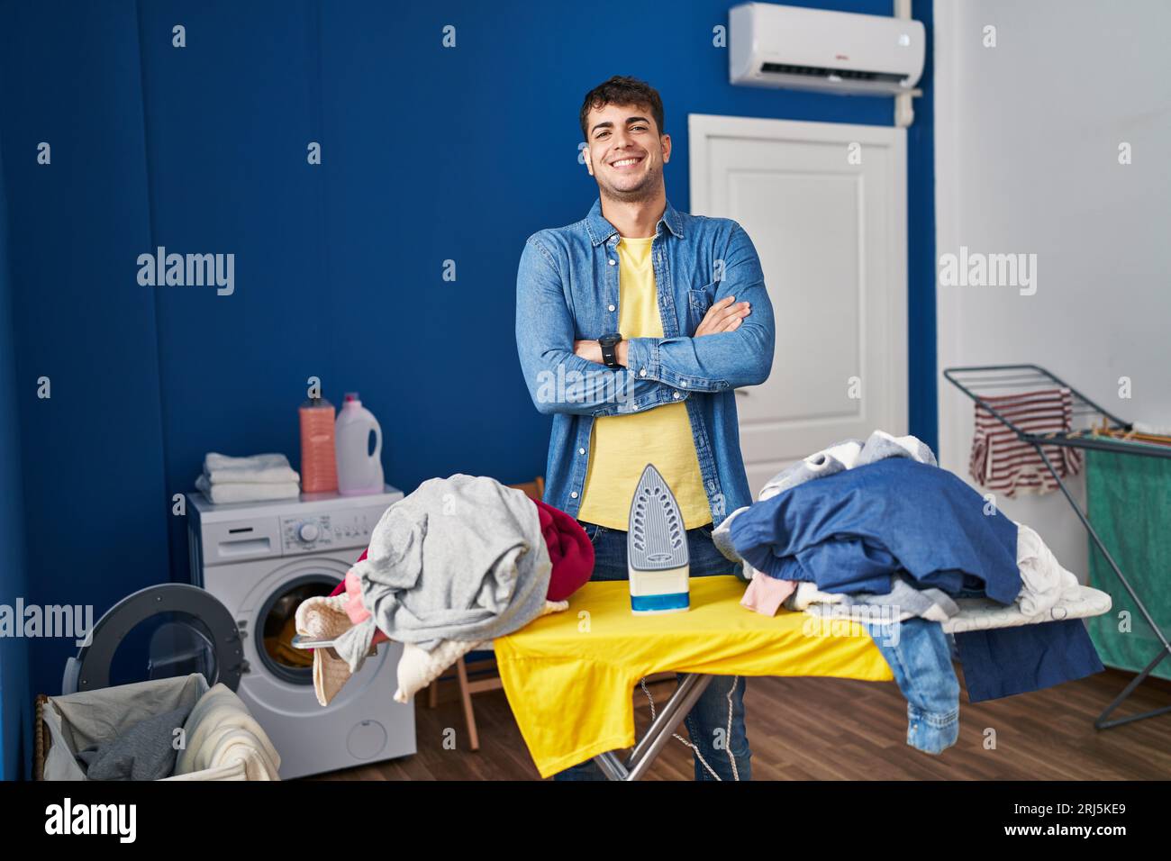 Young hispanic man ironing clothes at home happy face smiling with ...