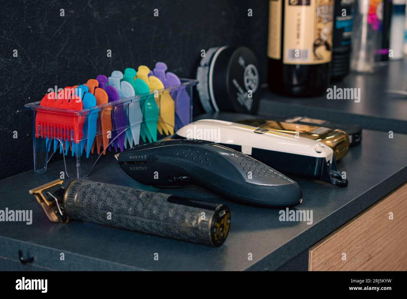 A selection of hair trimmers on a counter top at a barbershop next to ...