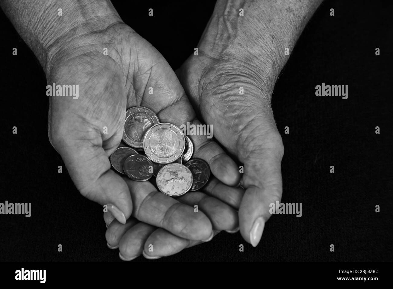 A man holding money coins in his hands as a symbol of poverty in ...