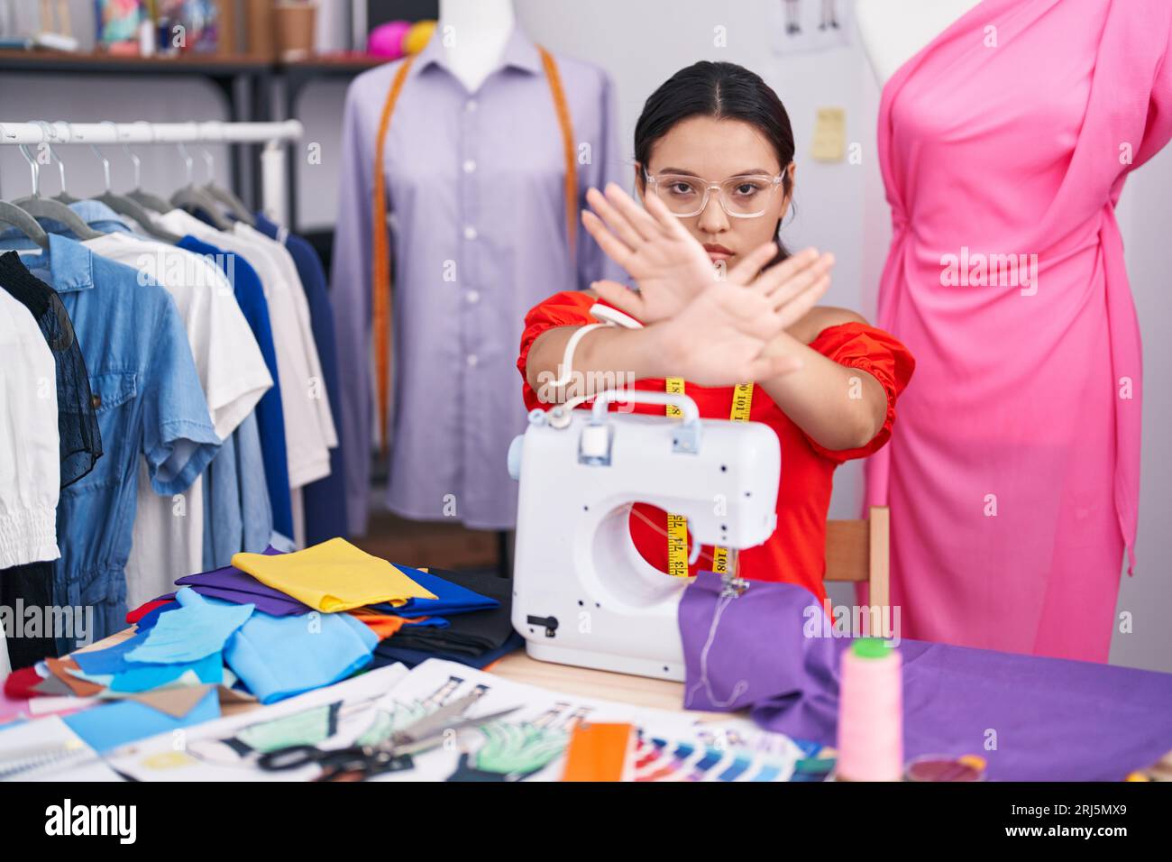 Hispanic young woman dressmaker designer using sewing machine rejection ...