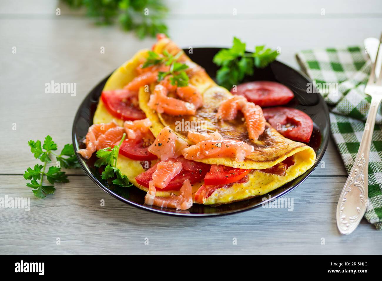 Fried omelette with tomatoes, vegetables and pieces of lightly salted ...