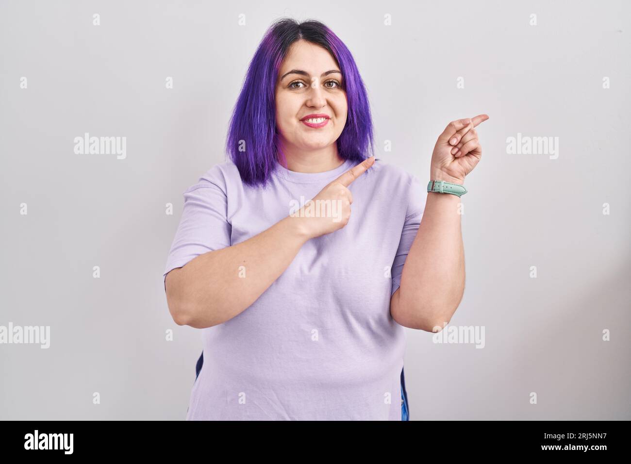 Plus size woman wit purple hair standing over isolated background ...