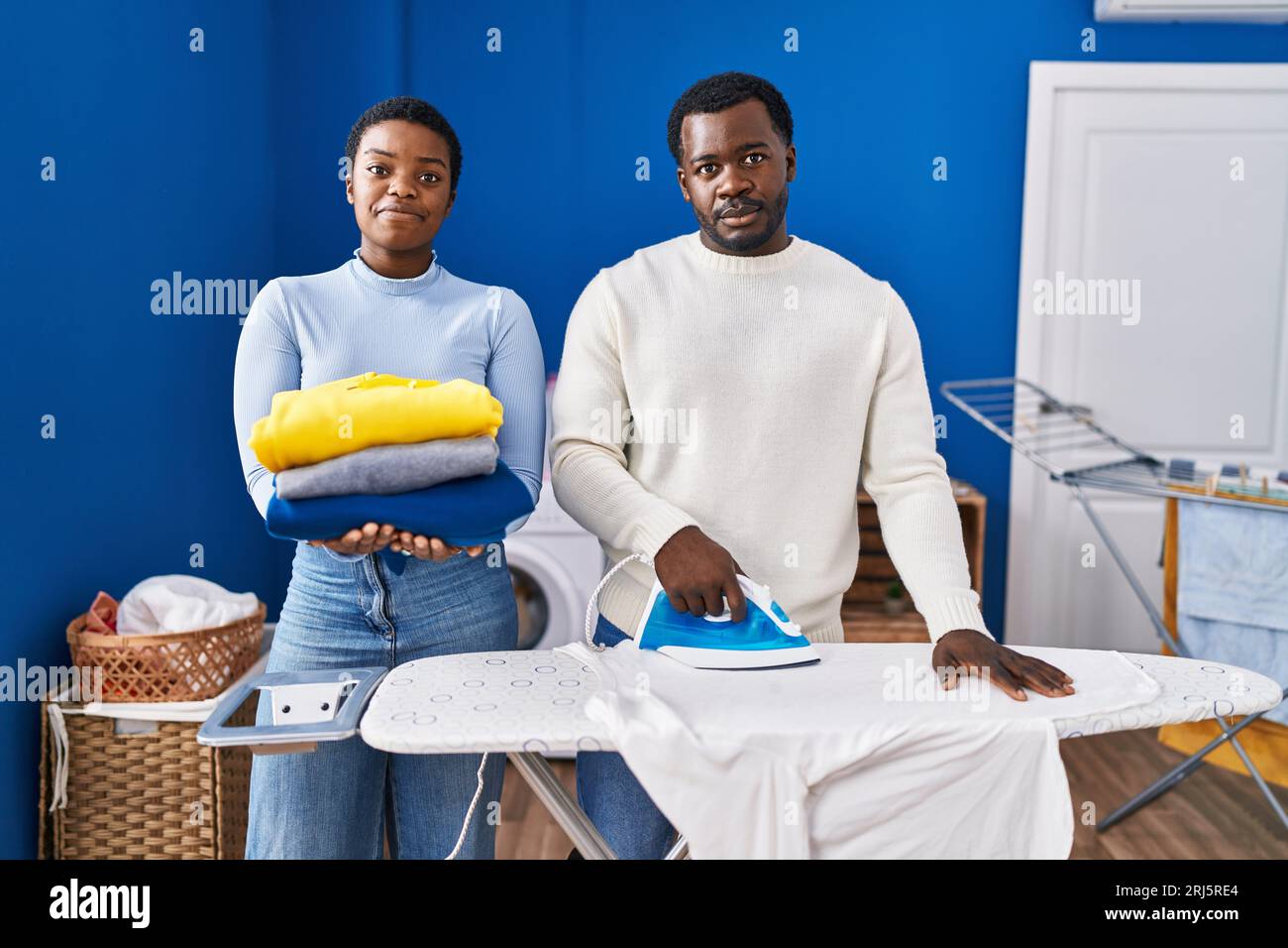 Young african american couple ironing clothes at laundry room relaxed ...
