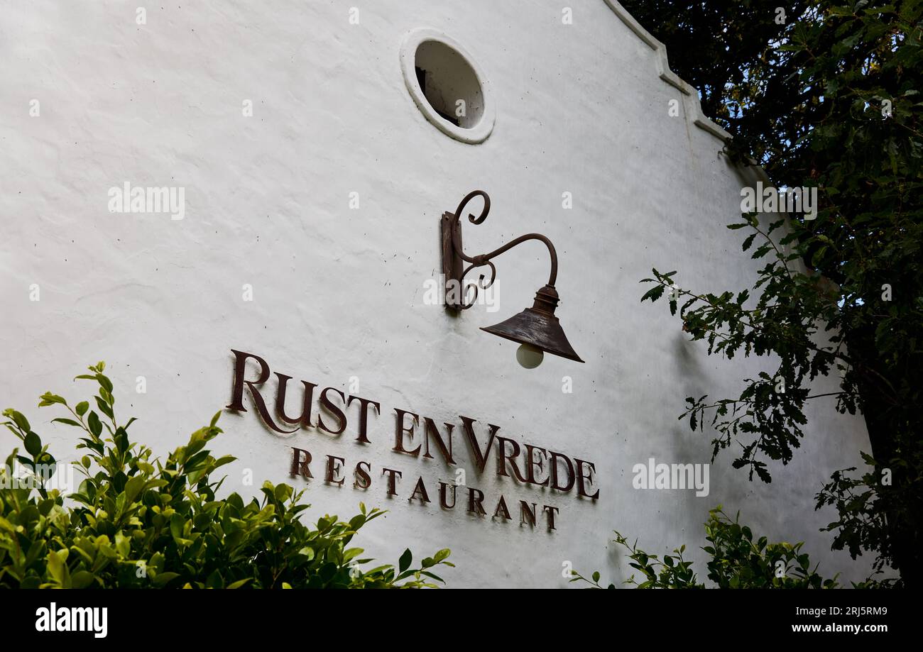 The wall of Rust en Vrede Wine Estate with an old lamp and lettering ...