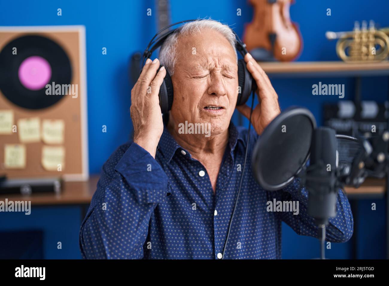 Senior grey-haired man artist singing song at music studio Stock Photo ...