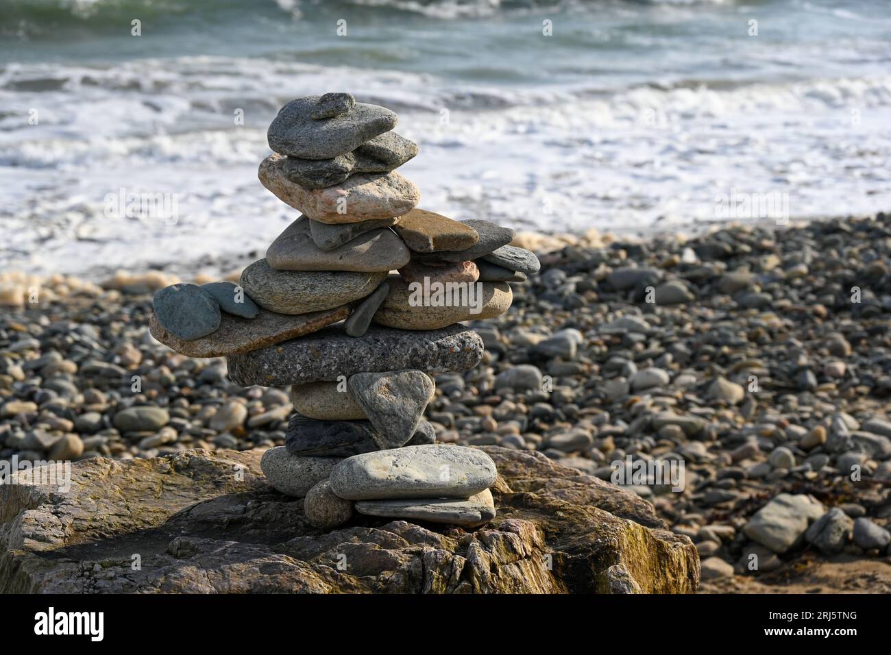 A stunning beach shore with stone stacked in a tower Stock Photo - Alamy