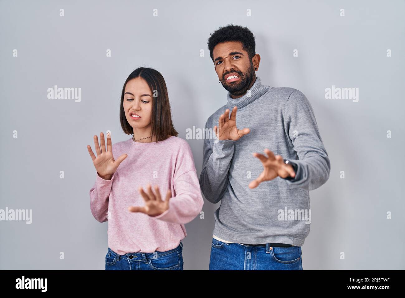 Young hispanic couple standing together disgusted expression ...