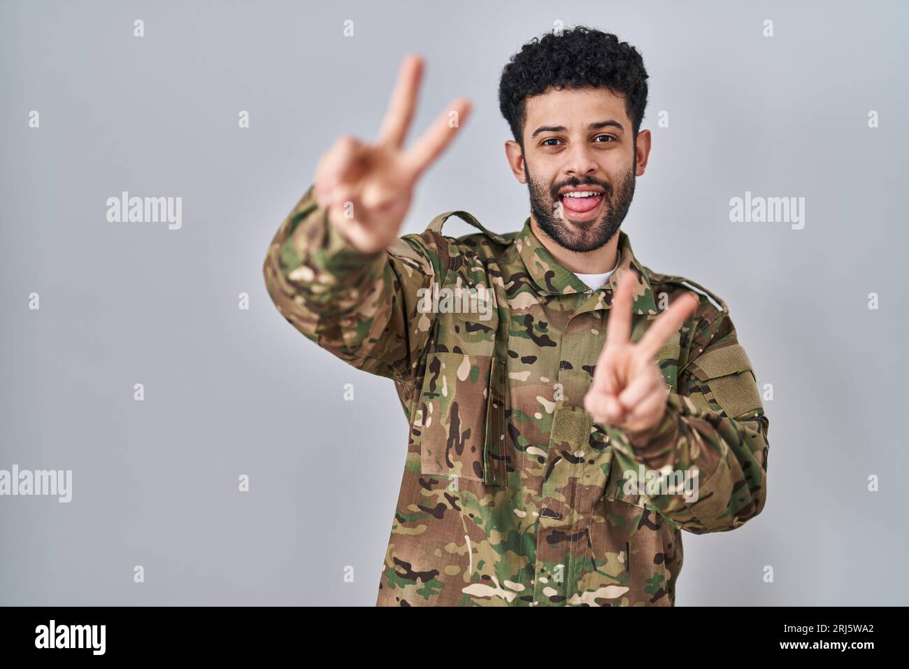 Arab man wearing camouflage army uniform smiling with tongue out ...