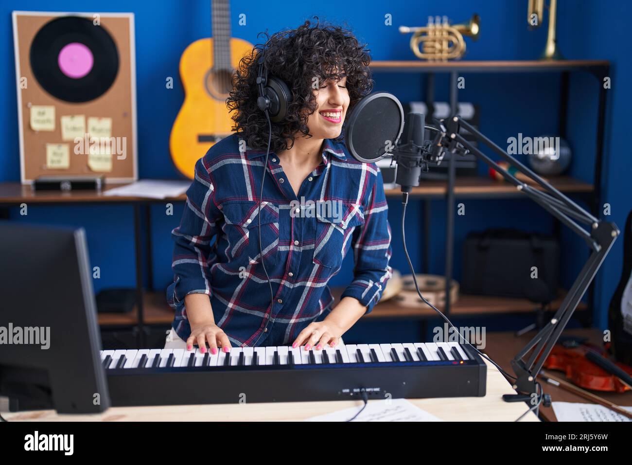 Young middle east woman musician singing song playing piano keyboard at ...