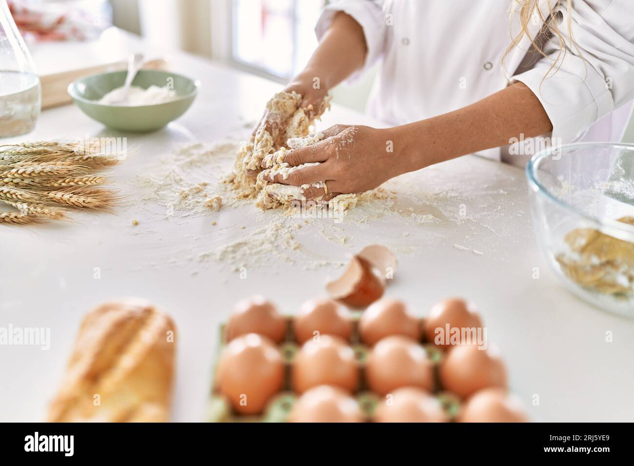 Young woman wearing cook uniform kneading flour at kitchen Stock Photo ...