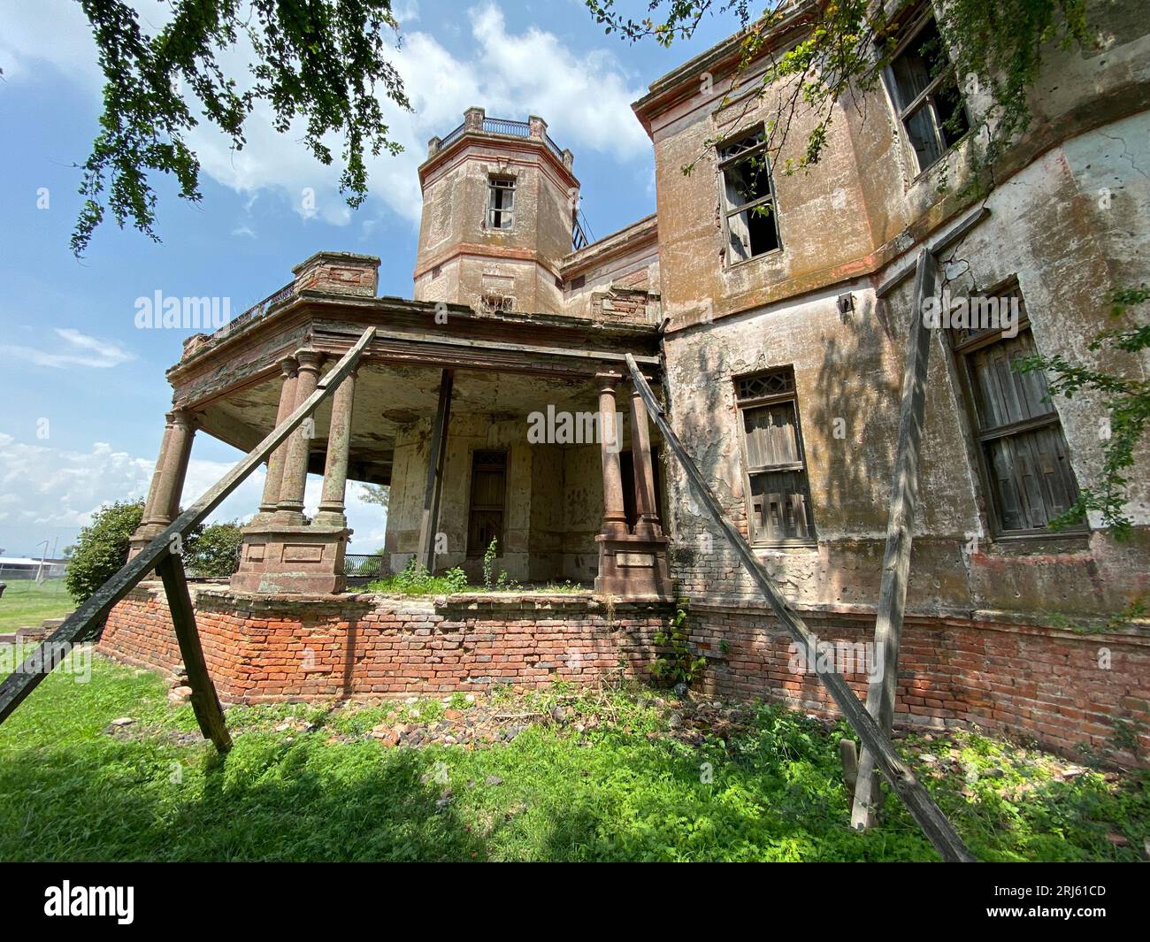 An abandoned building with a tall tower and shattered windows ...