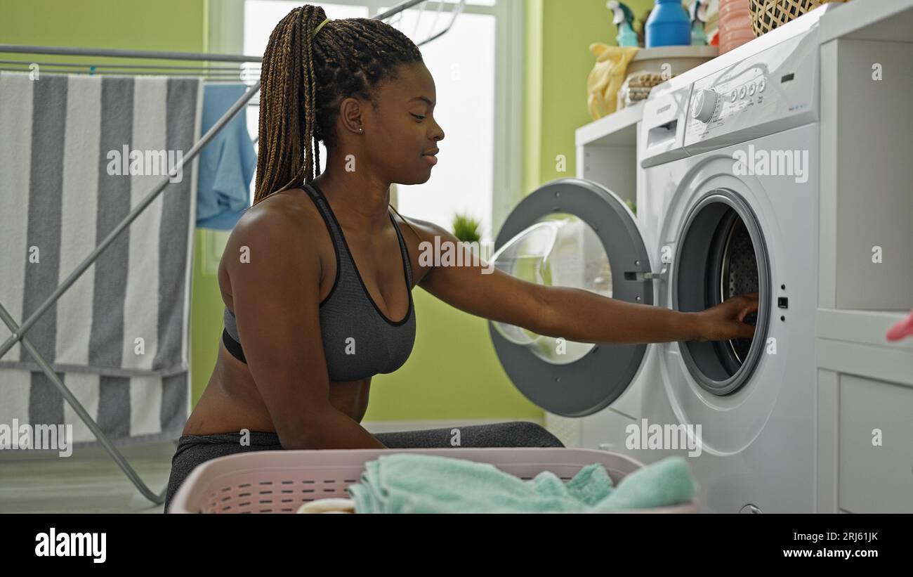 African american woman washing clothes at laundry room Stock Photo - Alamy