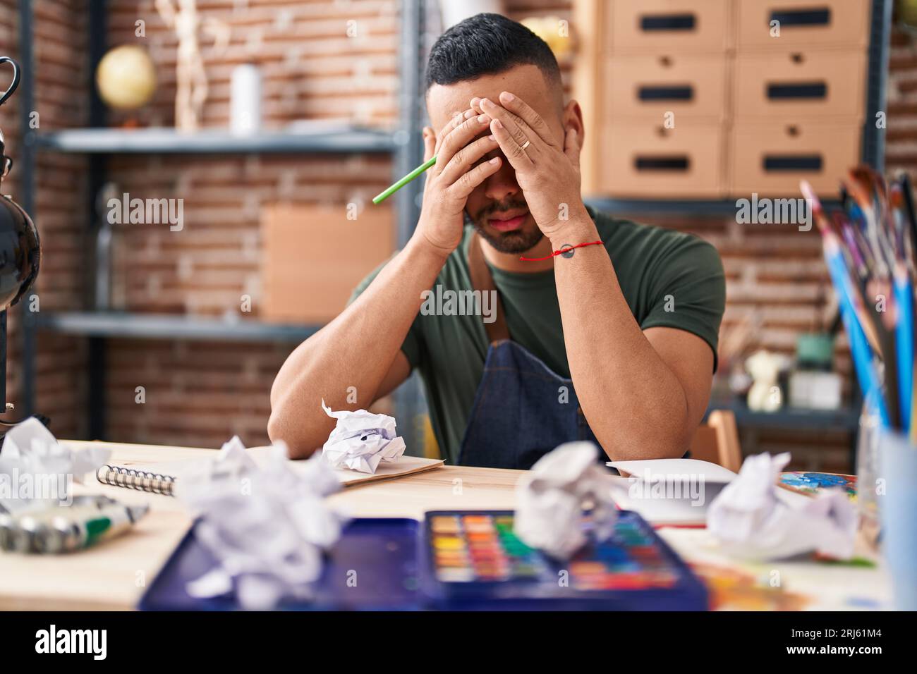 African american man artist stressed sitting on table at art studio ...