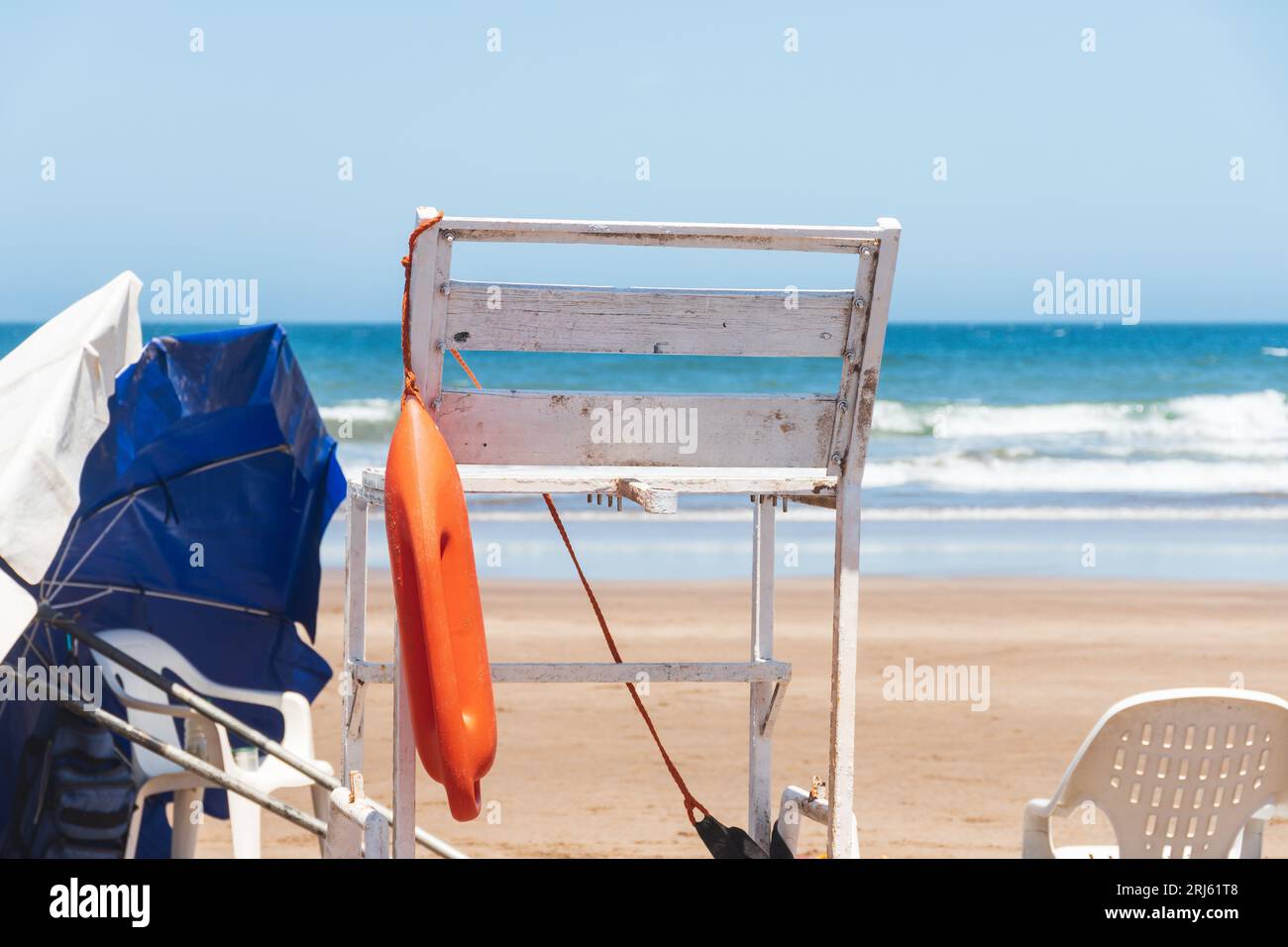 An empty lifeguard station on the beach with chair and umbrella Stock ...