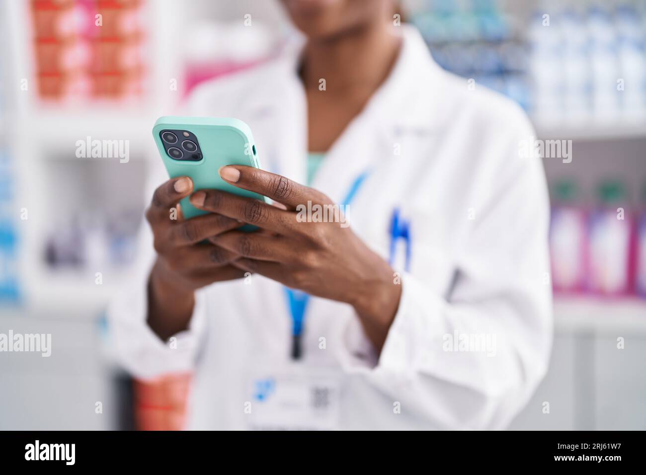 African american woman pharmacist using smartphone working at pharmacy ...