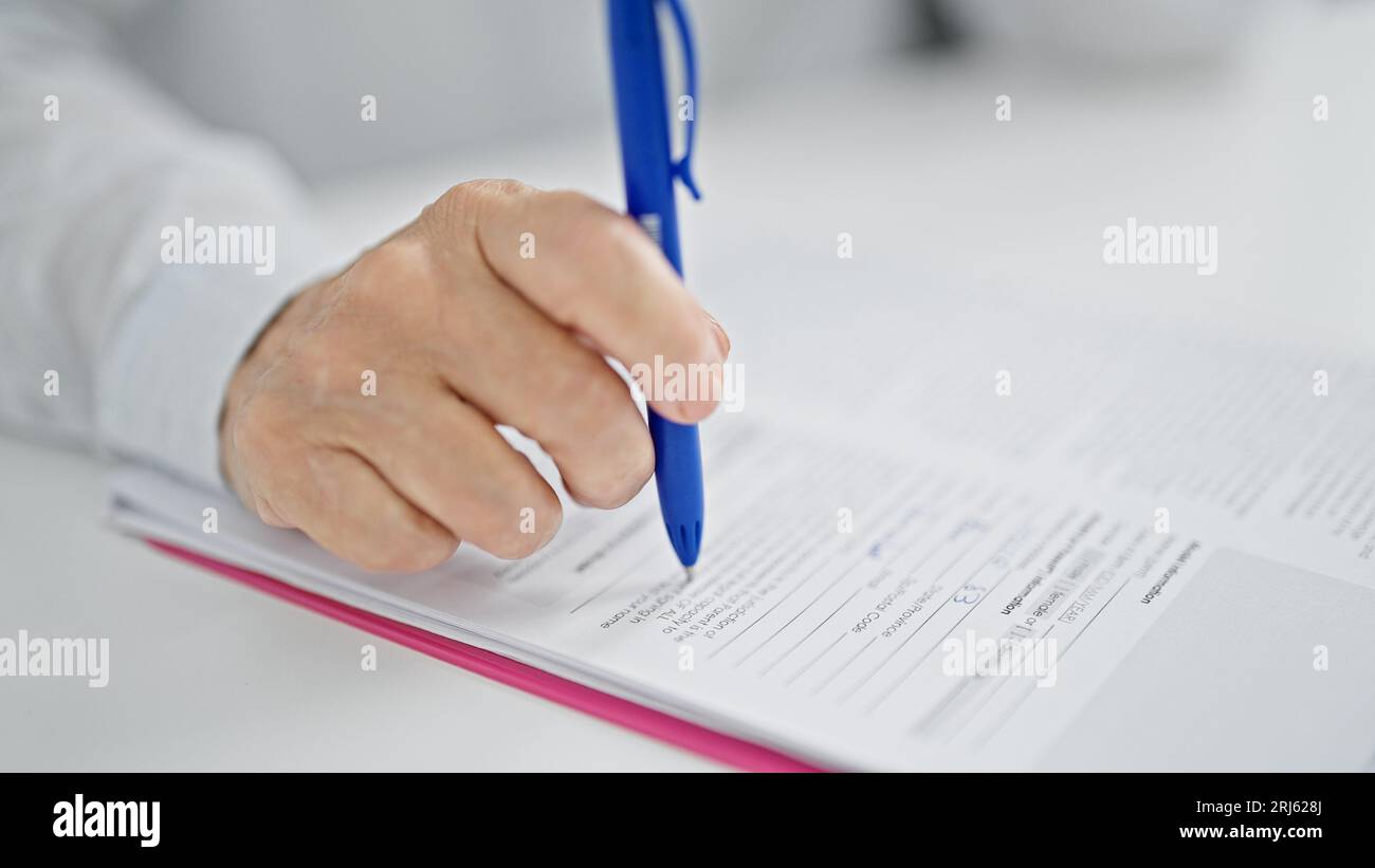 Middle age woman signing document at the office Stock Photo - Alamy