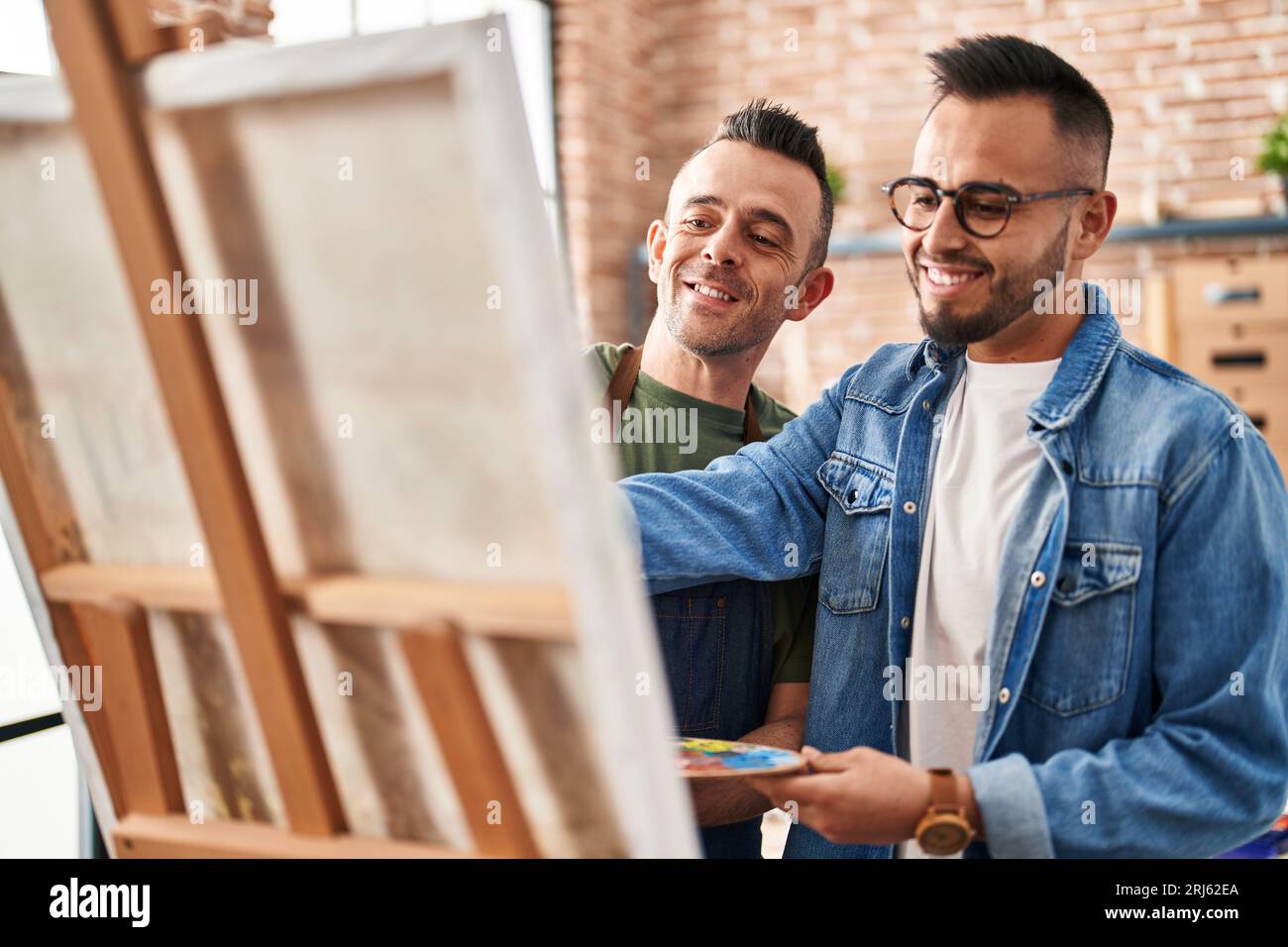 Two men artists smiling confident drawing at art studio Stock Photo - Alamy