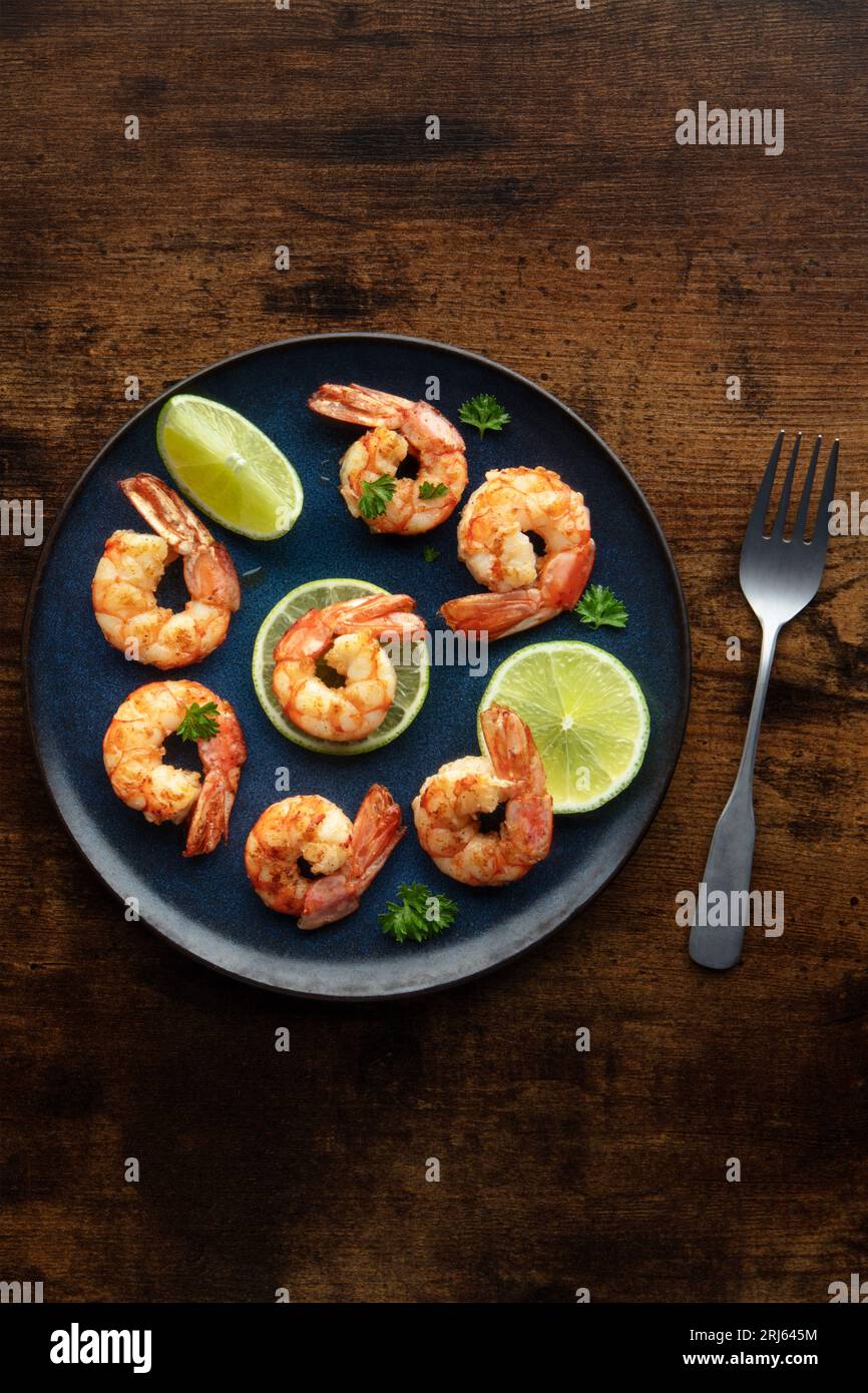 Shrimps with parsley and lime, overhead flat lay shot. Fried shrimp on ...