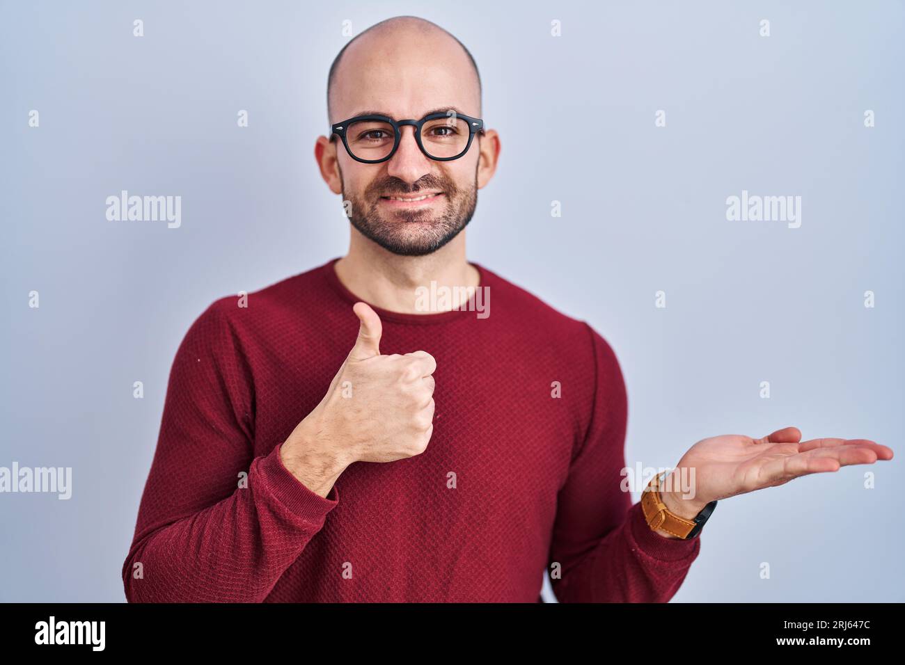 Young bald man with beard standing over white background wearing ...