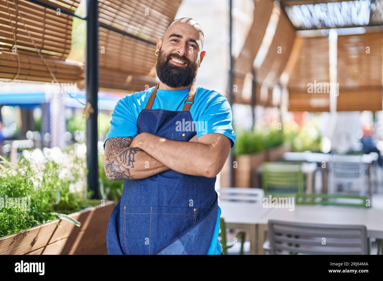 Young bald man waiter smiling confident standing with arms crossed ...
