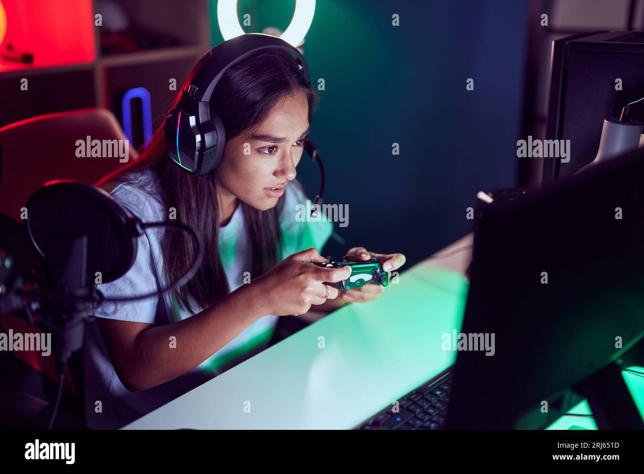 Young beautiful hispanic woman streamer playing video game using ...