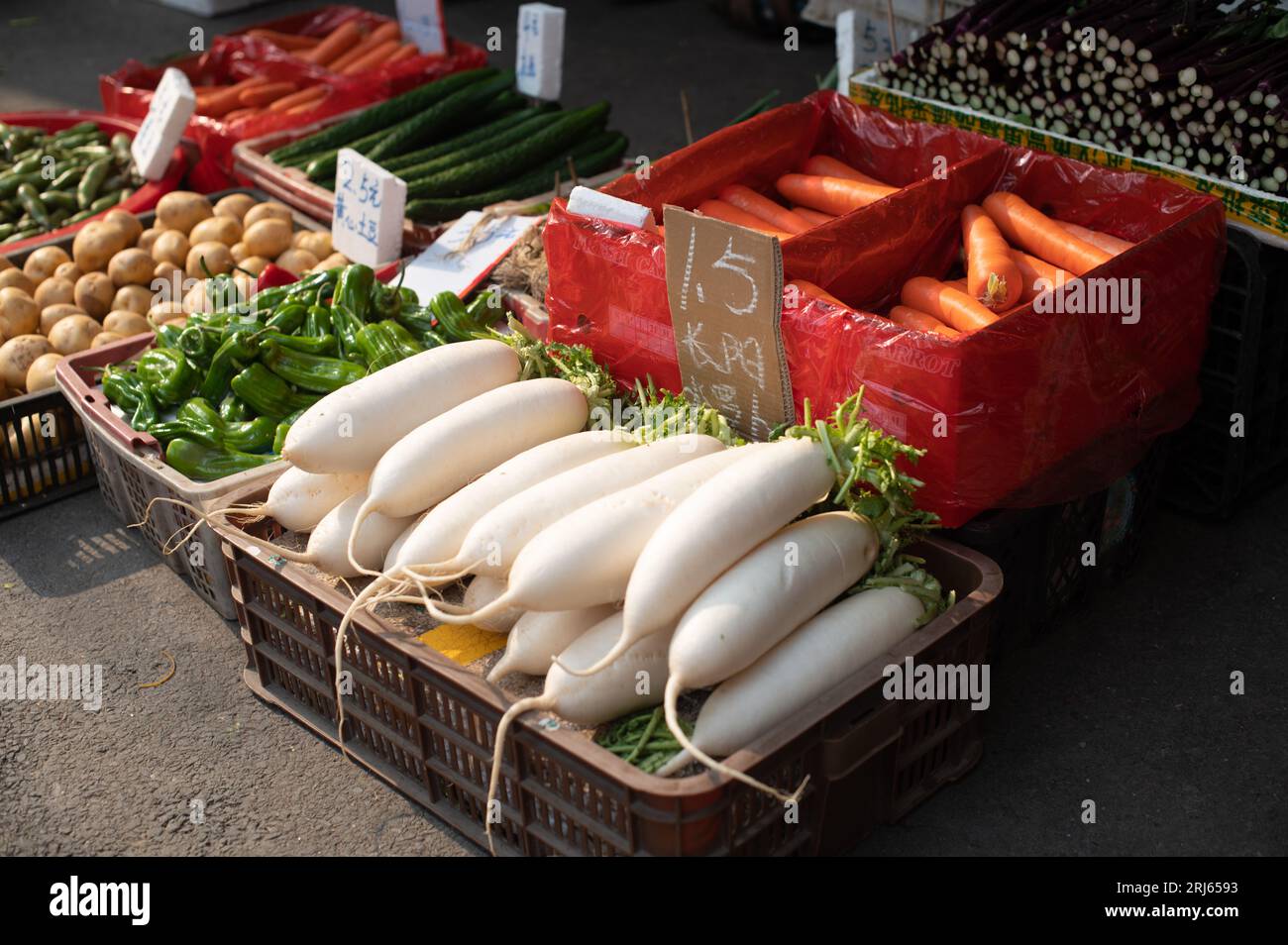 An array of fresh vegetables are on sale at an outdoor market stall ...