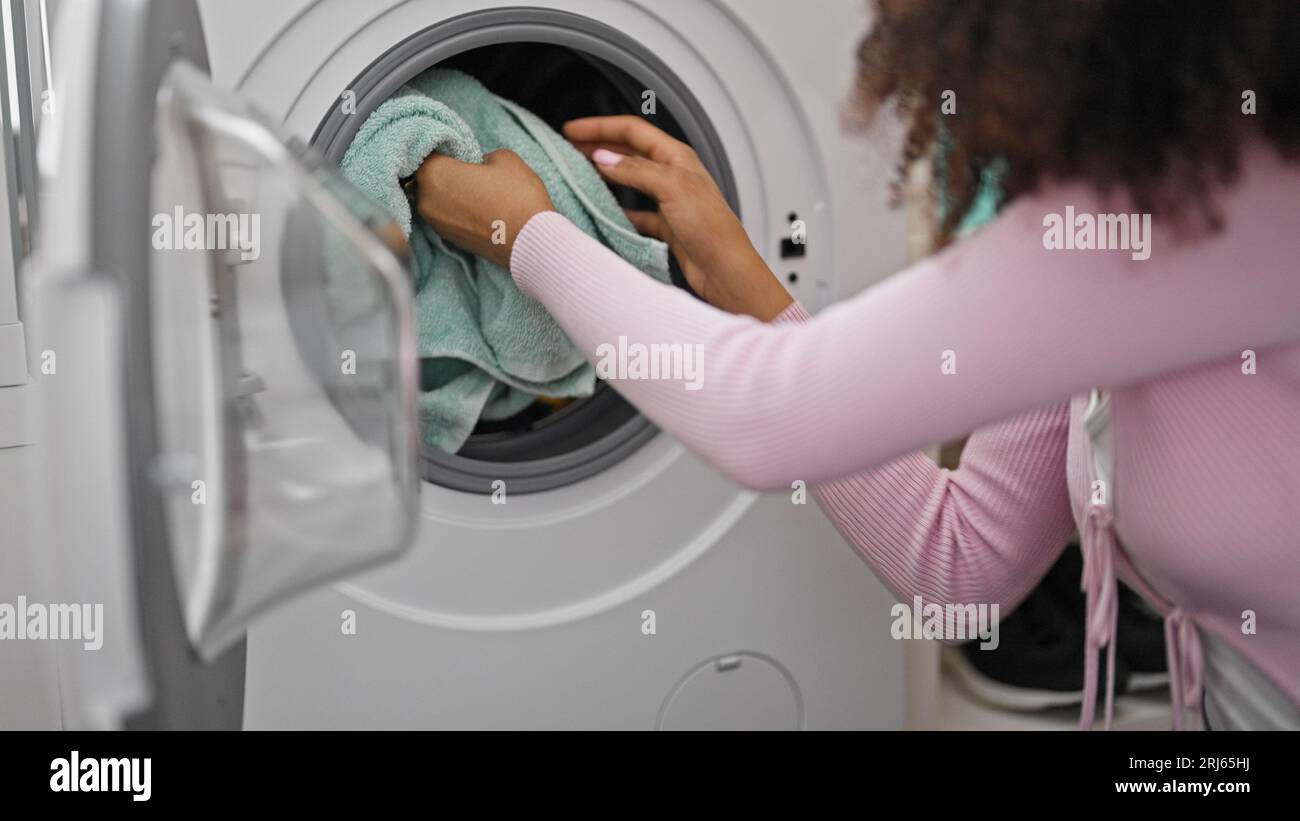African american woman washing clothes at laundry room Stock Photo - Alamy