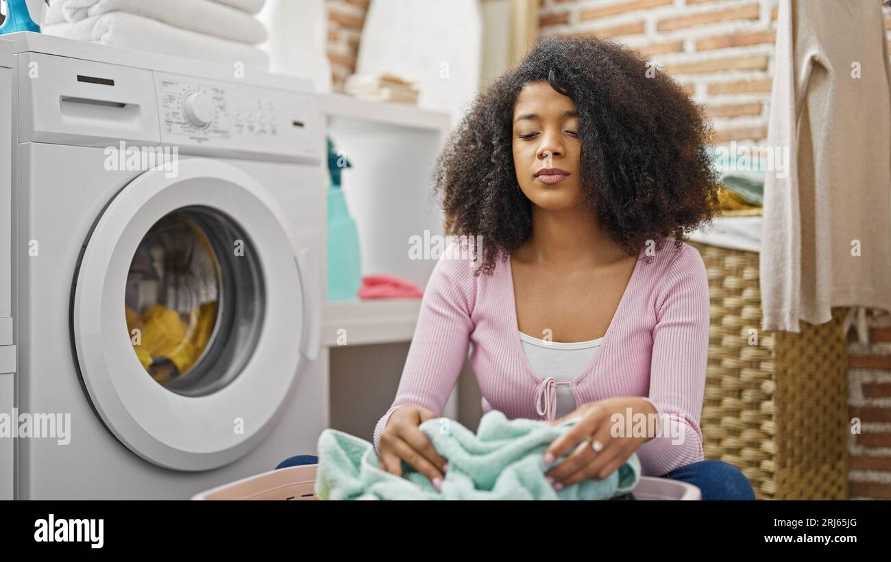 African american woman washing clothes at laundry room Stock Photo - Alamy