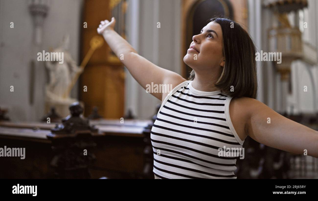 Young beautiful hispanic woman visiting church with open arms at ...