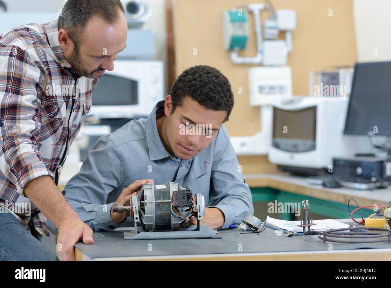 engineer teaching apprentice to fix computerized engine Stock Photo - Alamy