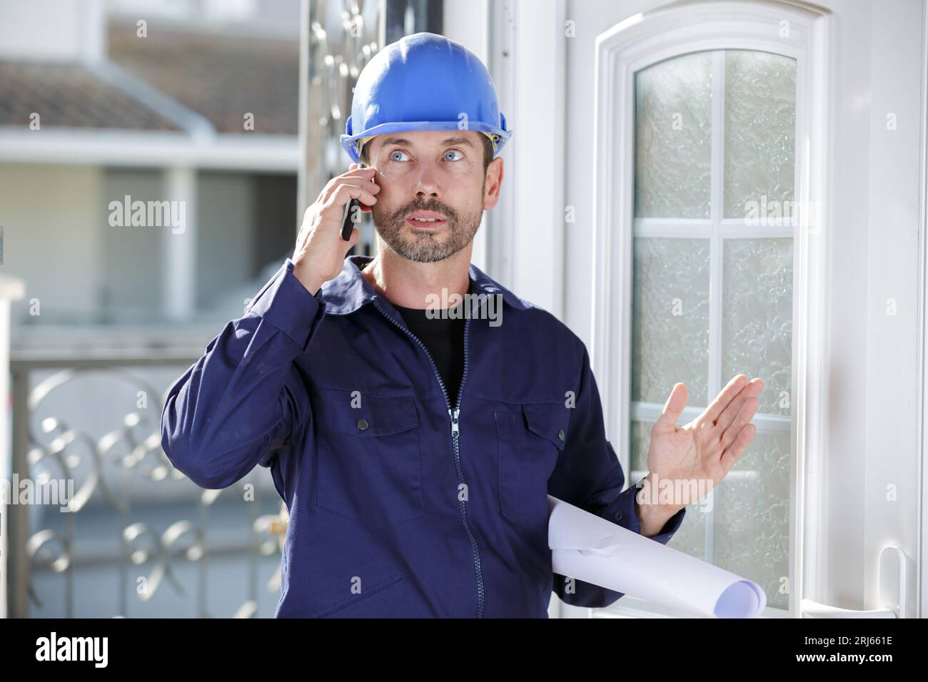 concerned construction manager talking on telephone Stock Photo - Alamy