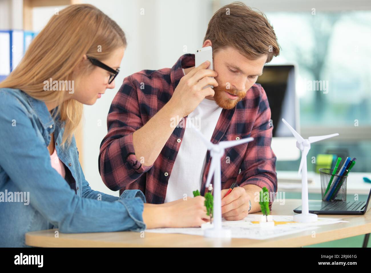 architects sitting around table having meeting Stock Photo - Alamy