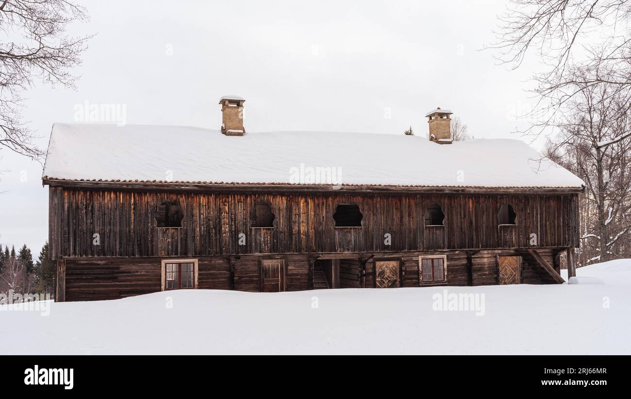 An idyllic winter scene featuring a wooden cabin situated in the snow ...