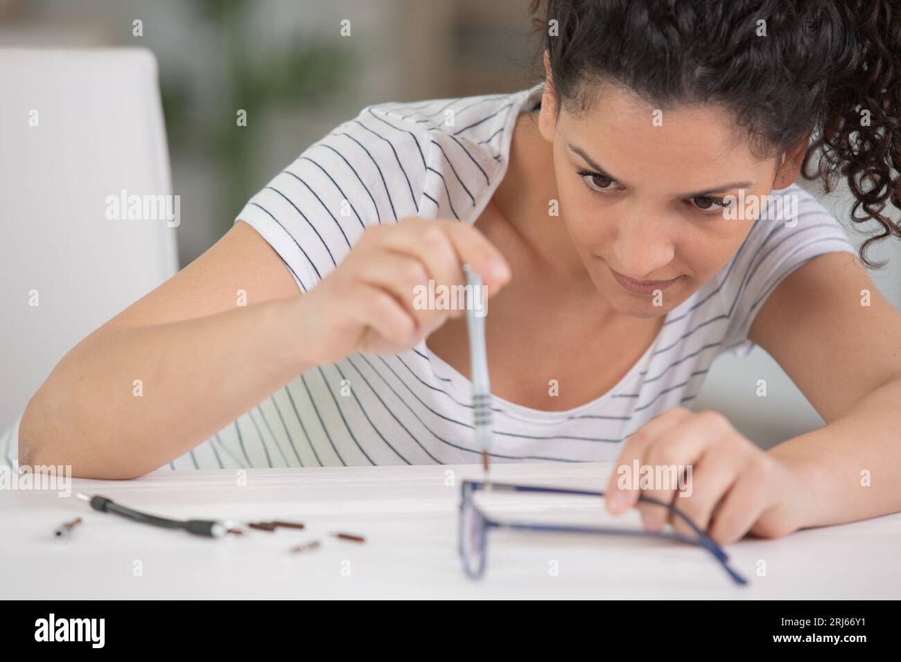 optician repairing spectacles with tool in optical store Stock Photo ...