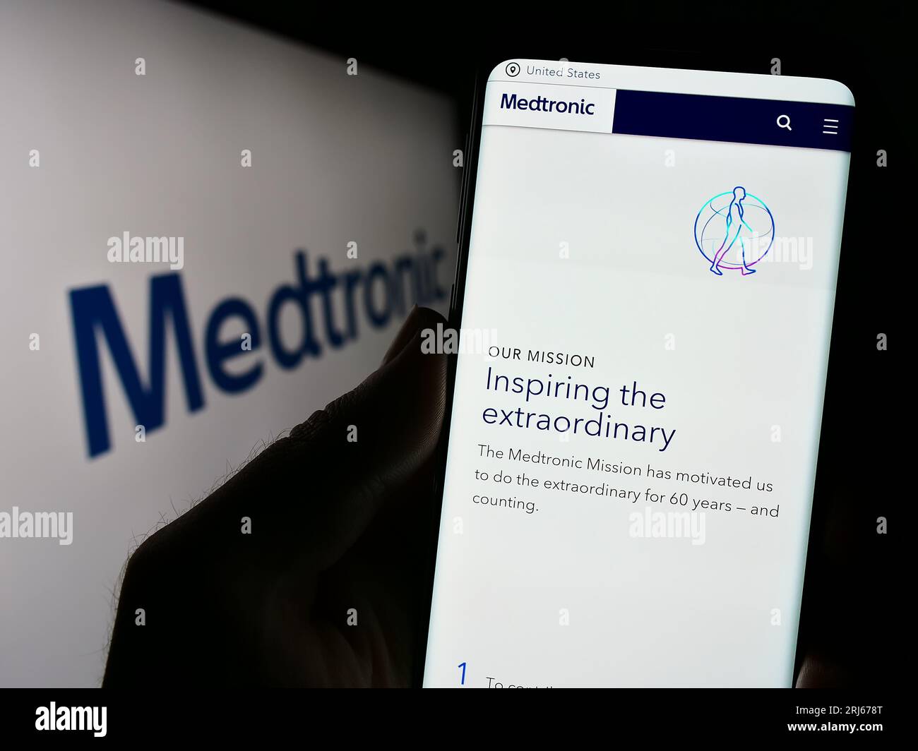 Person holding cellphone with webpage of medical technology company ...