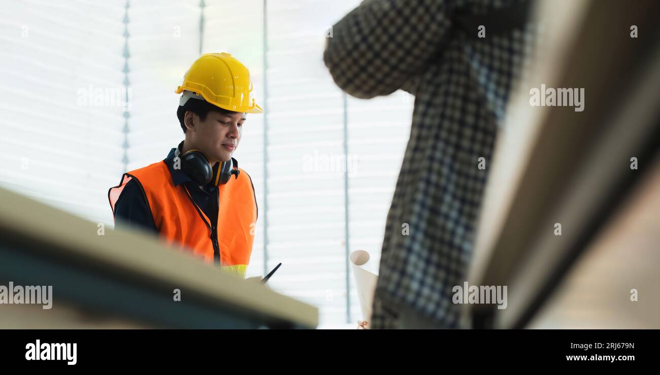 Young Asian engineer talking radio walkie talkie to operate and control ...