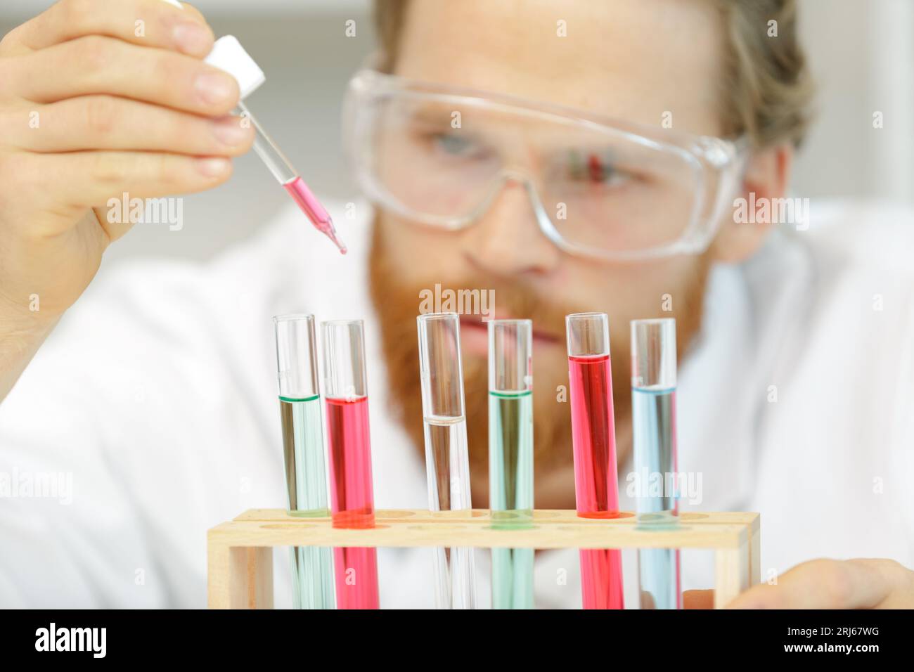 scientist dripping liquid from pipette into test tube Stock Photo - Alamy
