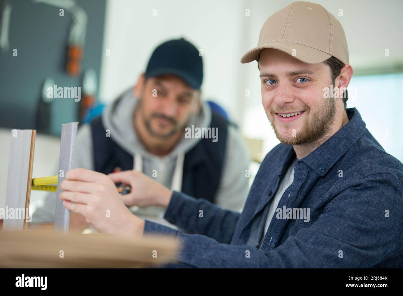 handsome bearded craftsman measuring width of wooden piece Stock Photo ...