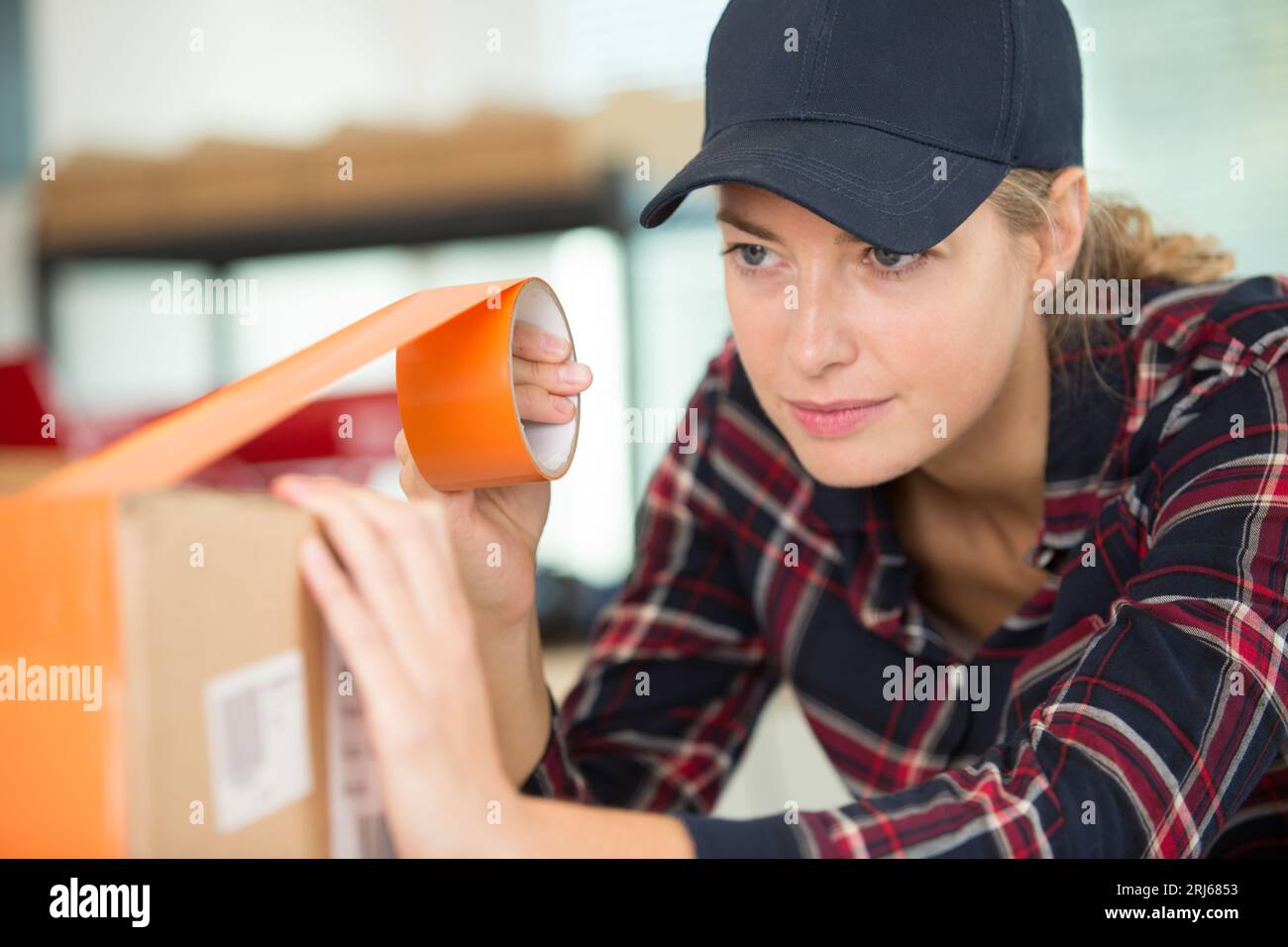 female worker moving packing and taping boxes Stock Photo - Alamy