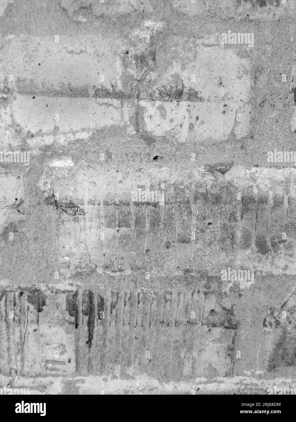 A black and white of an old stone wall with chipping paint and a ...