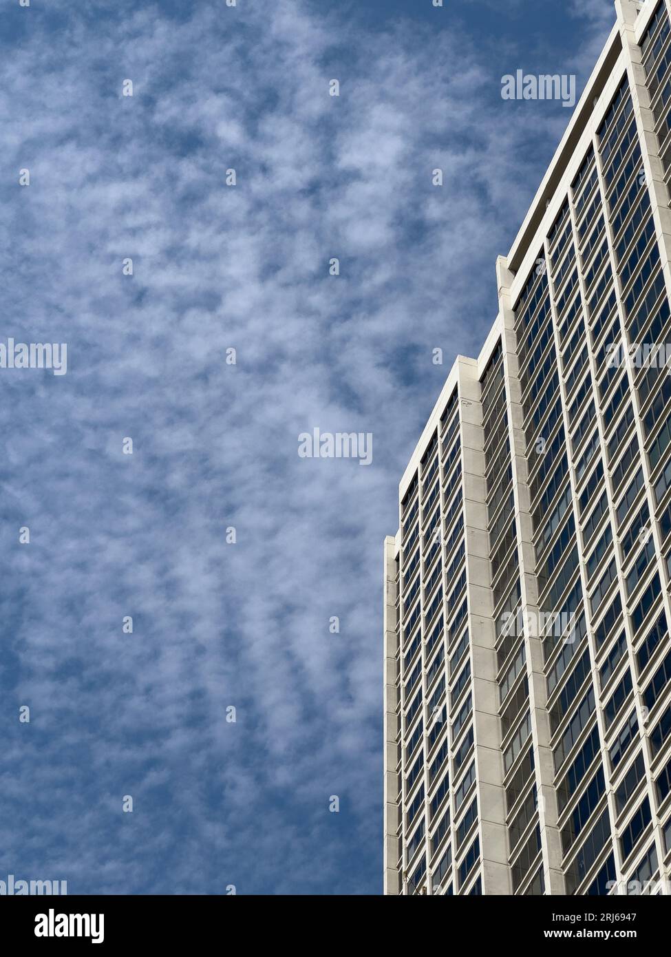 White wispy clouds frame a modern skyscraper Stock Photo - Alamy