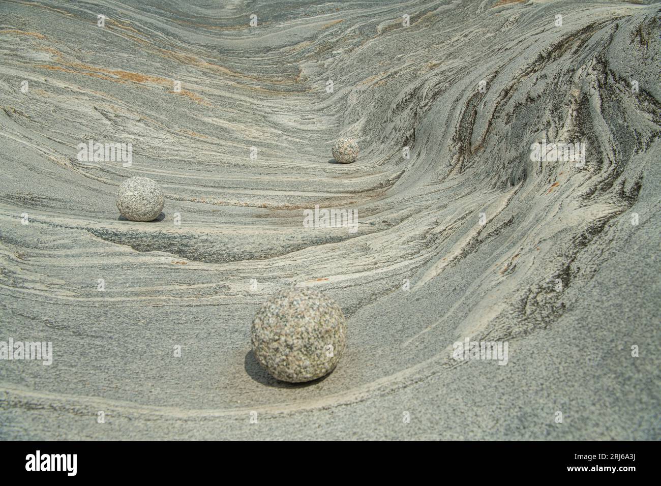 The granite stone waves as background with three round stones Stock ...