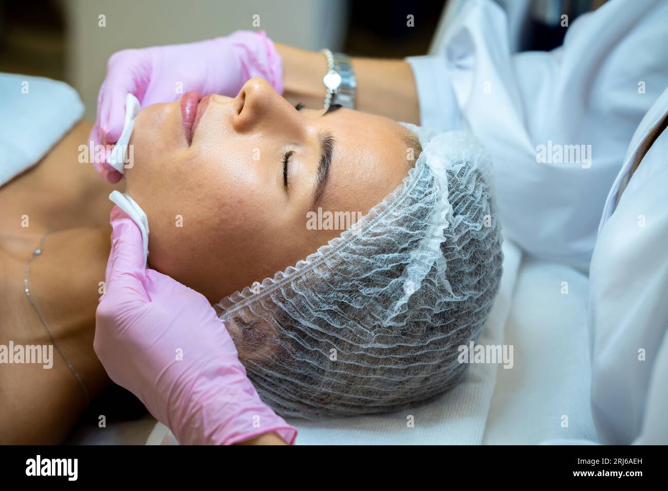 Female beautician doctor cleaning customer skin, make facial massage to ...