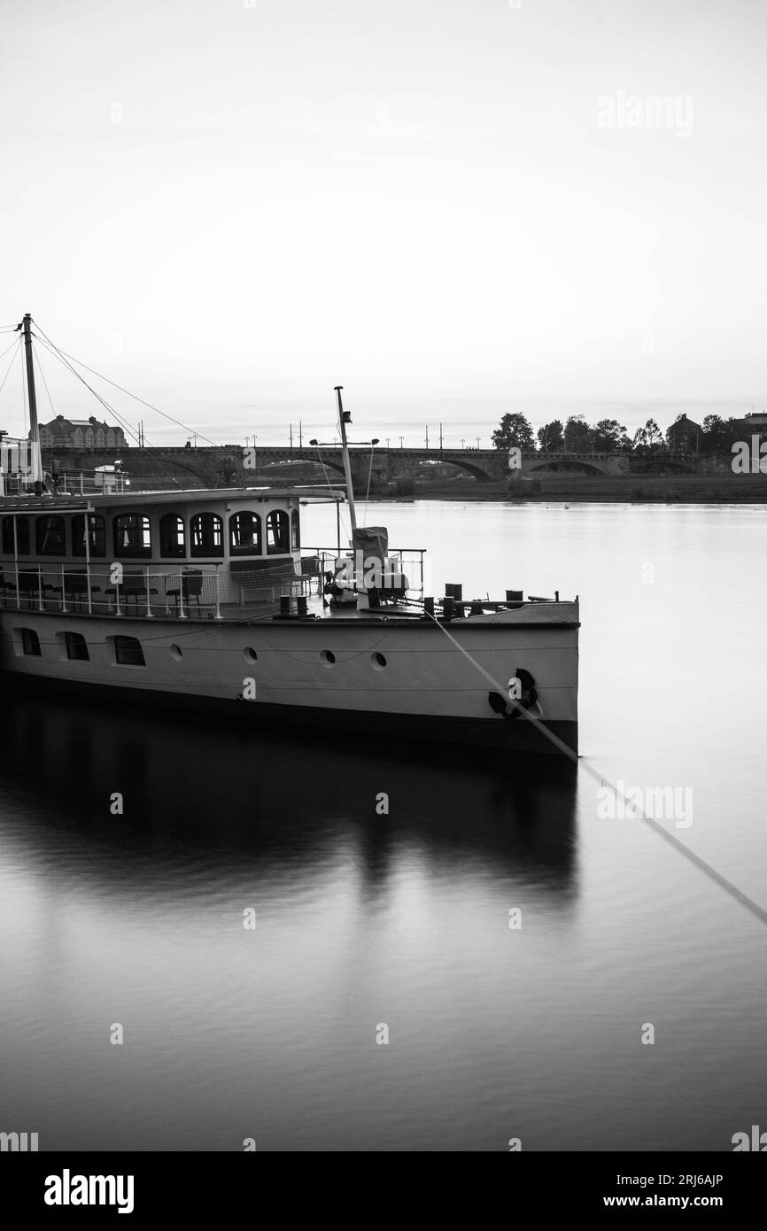 A small vessel sailing in a tranquil body of water with an arched ...